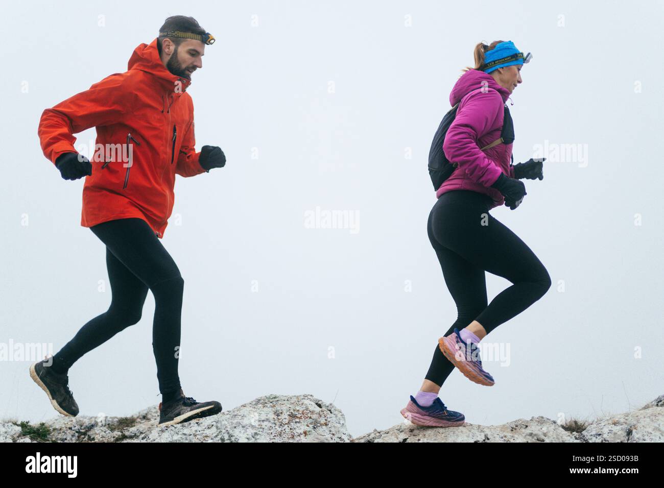 Trail running couple man and woman running on a mountain path Stock ...