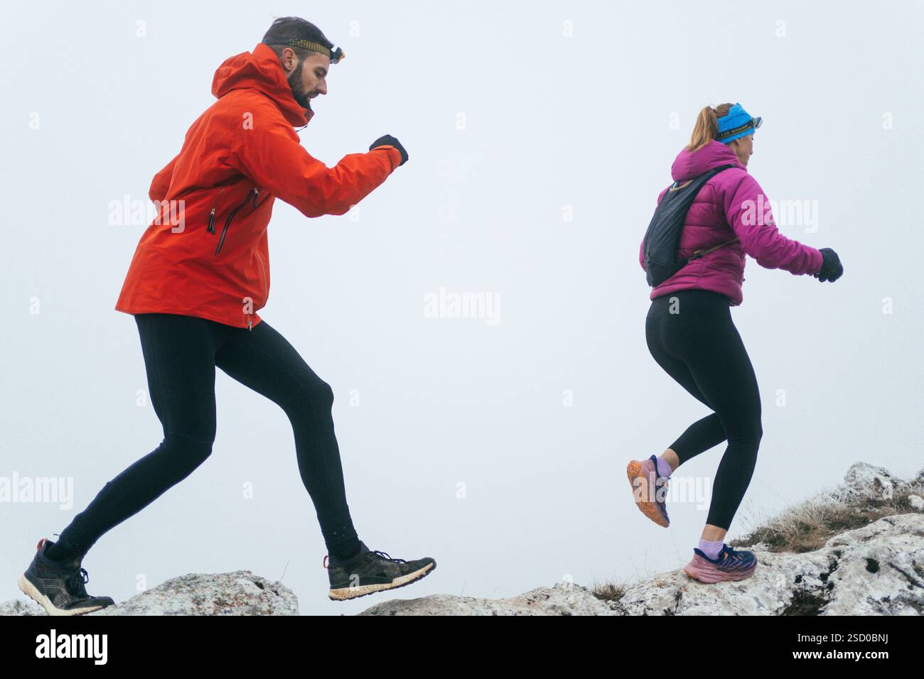 Trail running couple man and woman running on a mountain path Stock ...