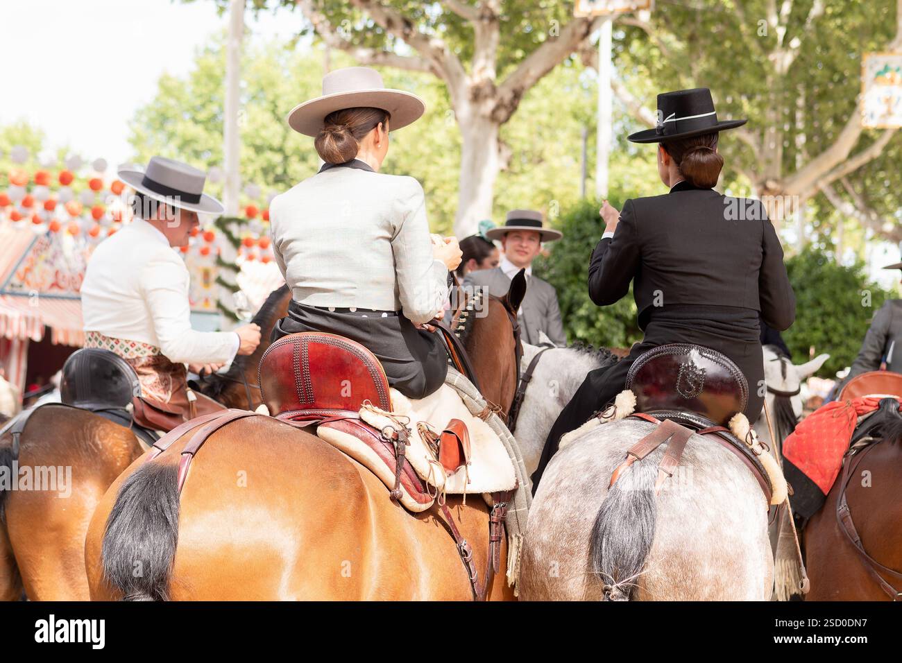 Group of Spanish riders in traditional attire on horseback at an ...