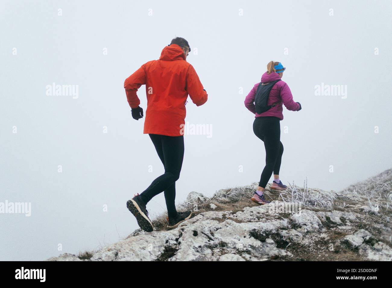 Trail running couple man and woman running on a mountain path Stock ...
