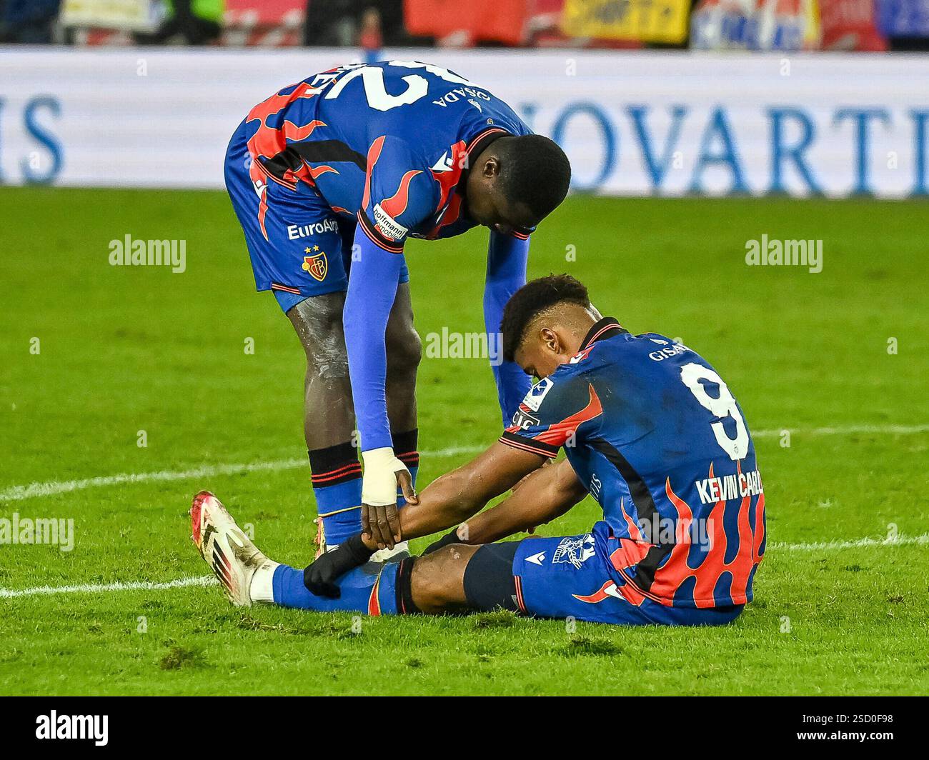 Leo Leroy (FC Basel, #22) schaut und beugt sich zu Kevin Carlos Omoruyi ...