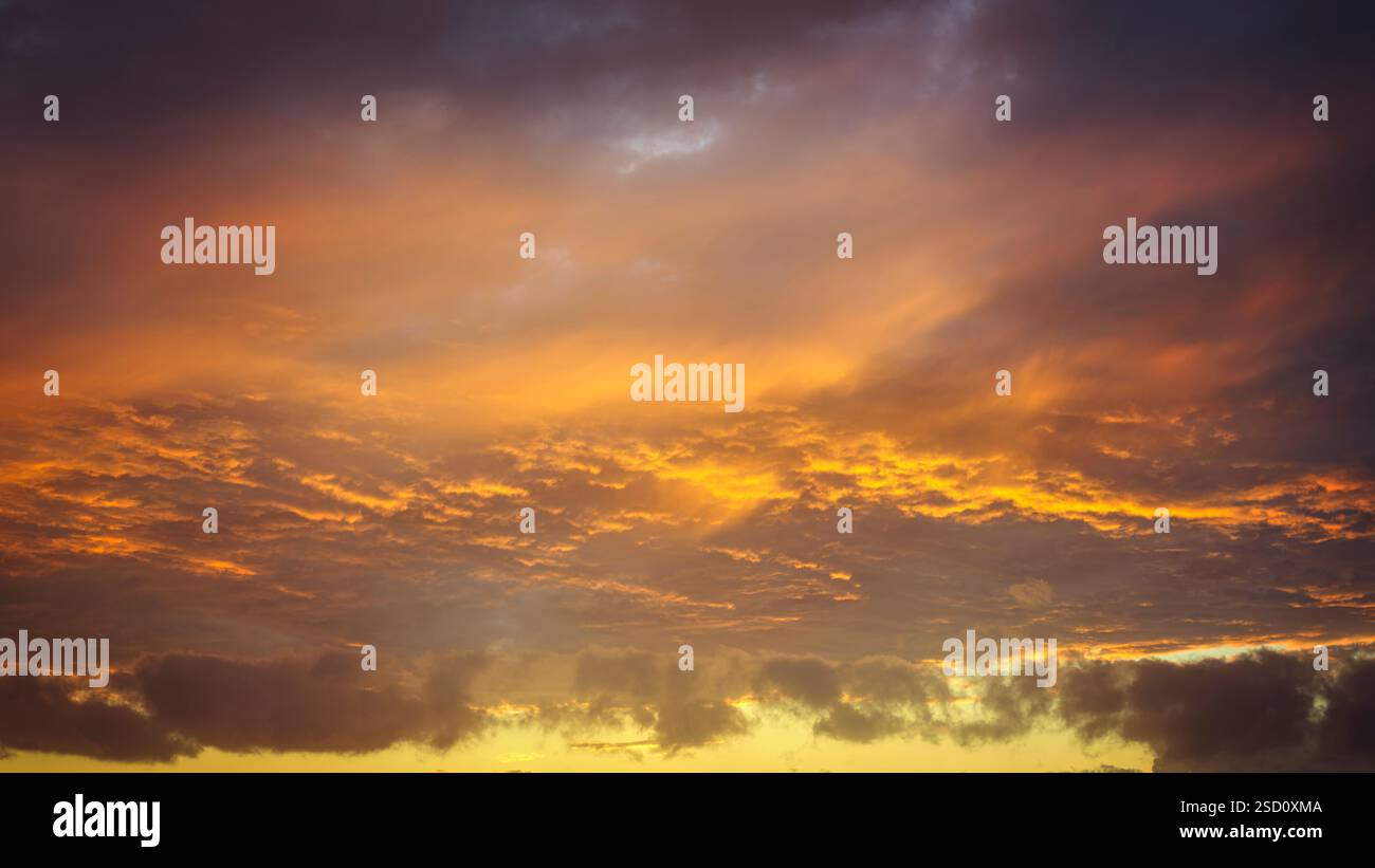 Dramatic red, orange, and yellow clouds in a real fiery sky at sunset. High resolution ...