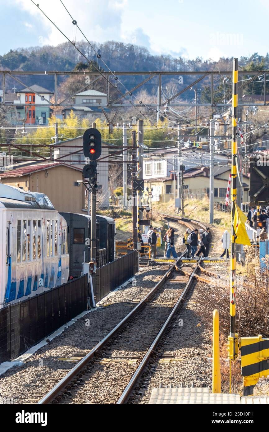 Train yard in Japan with multiple vintage trains and scenic mountains under a blue sky Stock ...