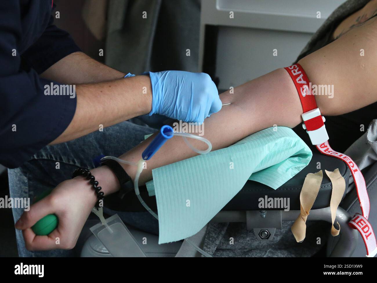 Cracow. Krakow. Poland. Donating the blood in mobile blood donation unit. Stucking the needle in ...