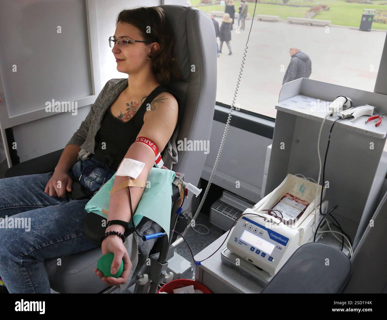 Cracow. Krakow. Poland. Donating the blood in mobile blood donation unit. Stucking the needle in ...