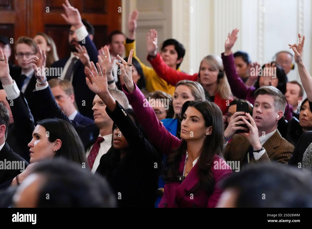 Reporters raise hands during a news conference with President Donald ...