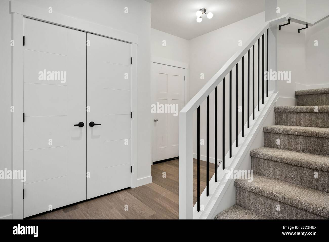 Staircase with a railing and a white door. The door is open and the ...