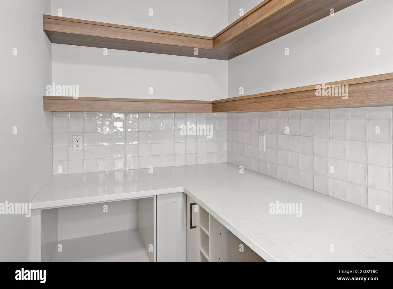 White kitchen with a white counter and a white shelf. The shelf is ...