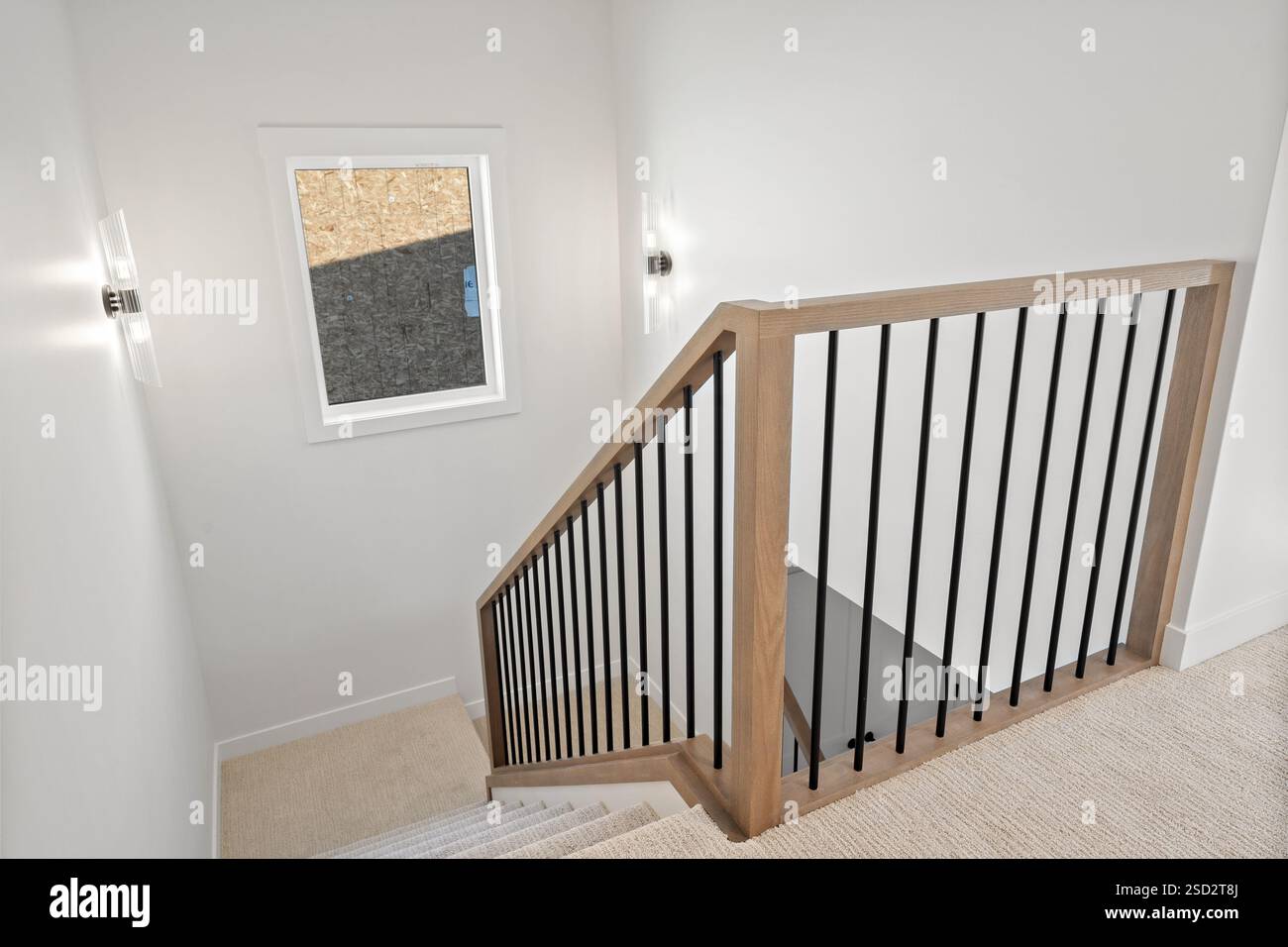 Staircase with a window above it and a railing below it. The railing is ...