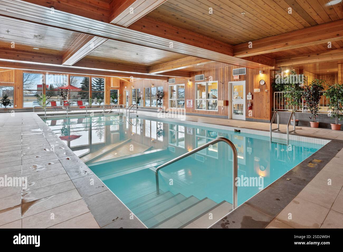 Large indoor pool with a wooden ceiling and a red and white umbrella ...