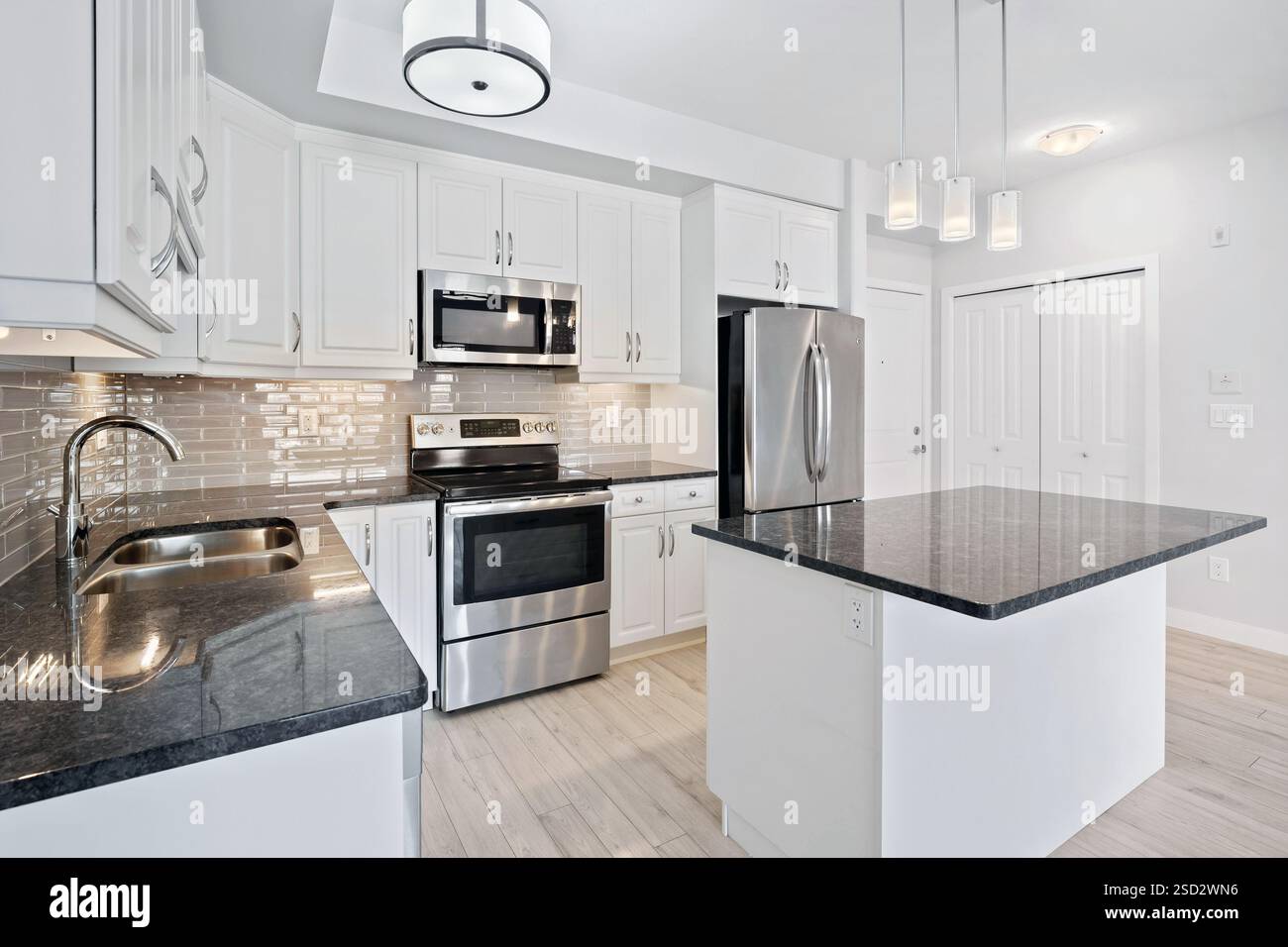 Clean and modern kitchen with a stainless steel stove and refrigerator ...