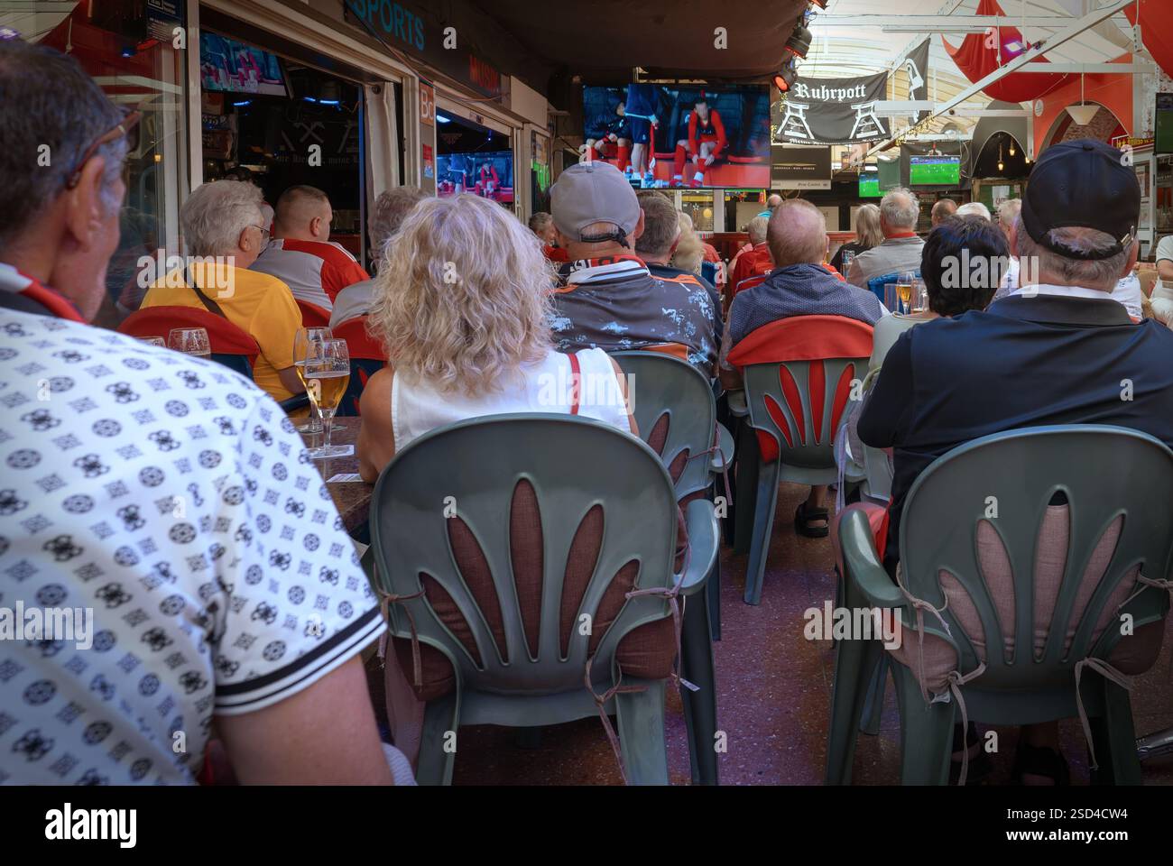 German soccer fans, tourists watch a soccer match together on vacation ...