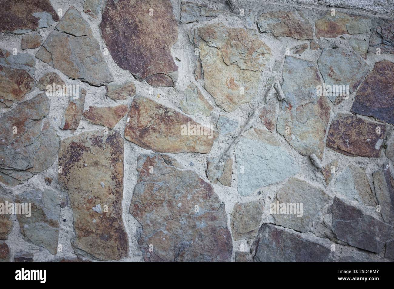 A close-up view showcases a rough stone wall composed of various shapes ...