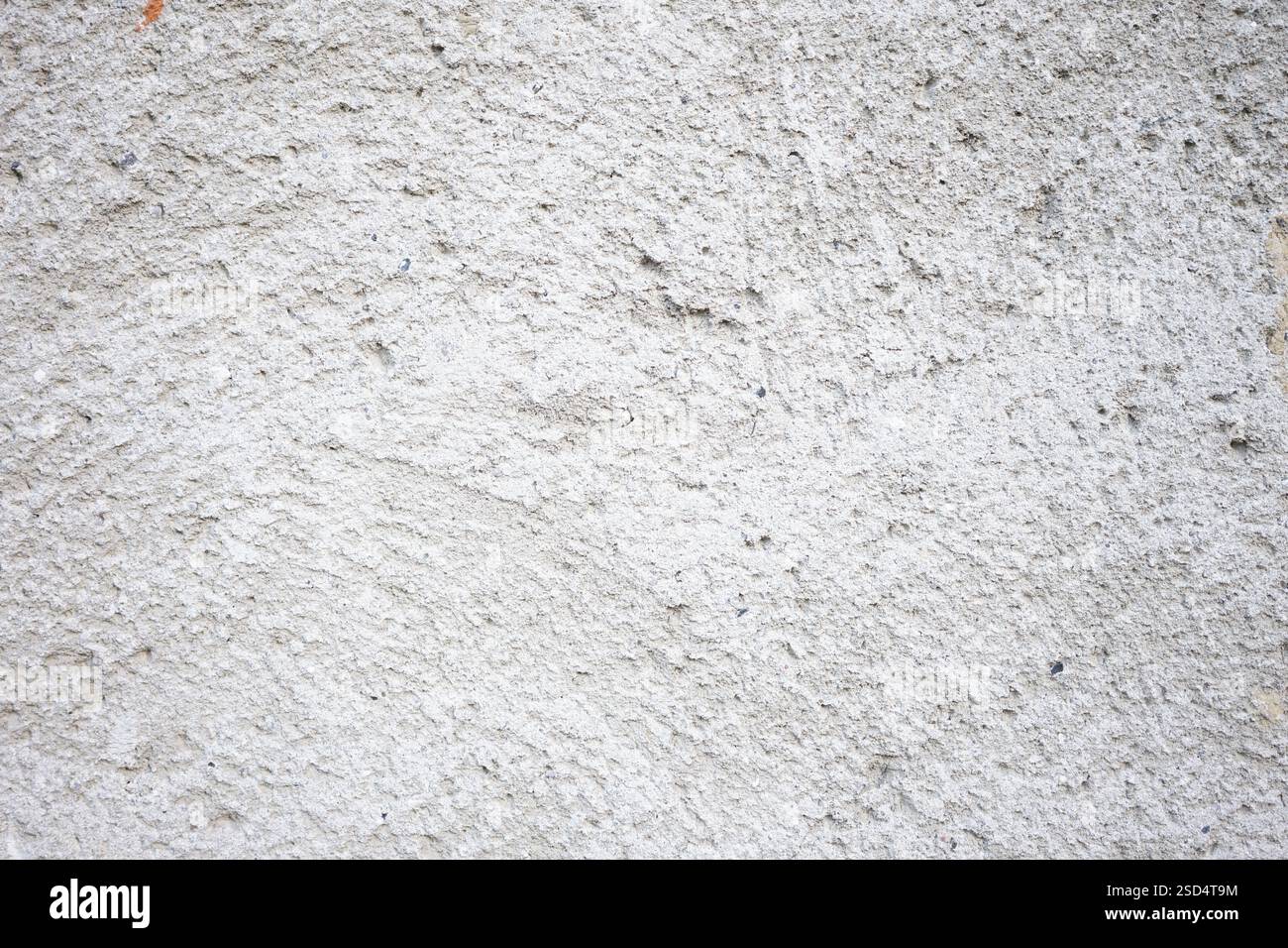 A close-up view of a textured gray wall highlights its uneven surface ...