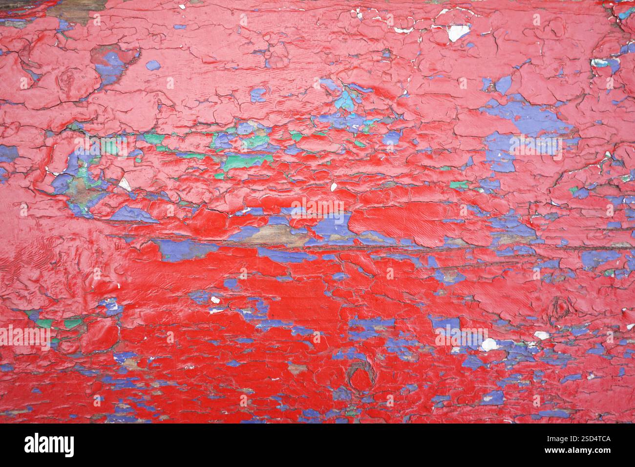 A close-up view reveals layers of bright red paint peeling away to ...