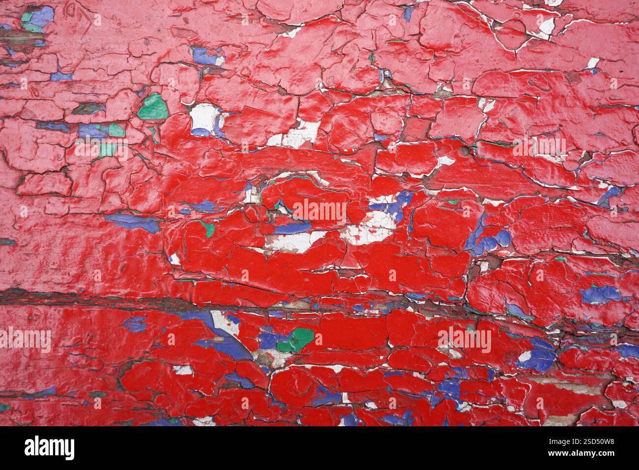This close-up view reveals a textured surface of cracked red paint ...
