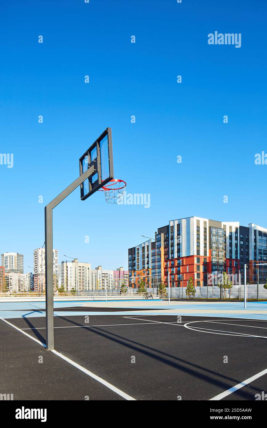 Basketball hoop on empty outdoor rubber court. Modern school campus ...