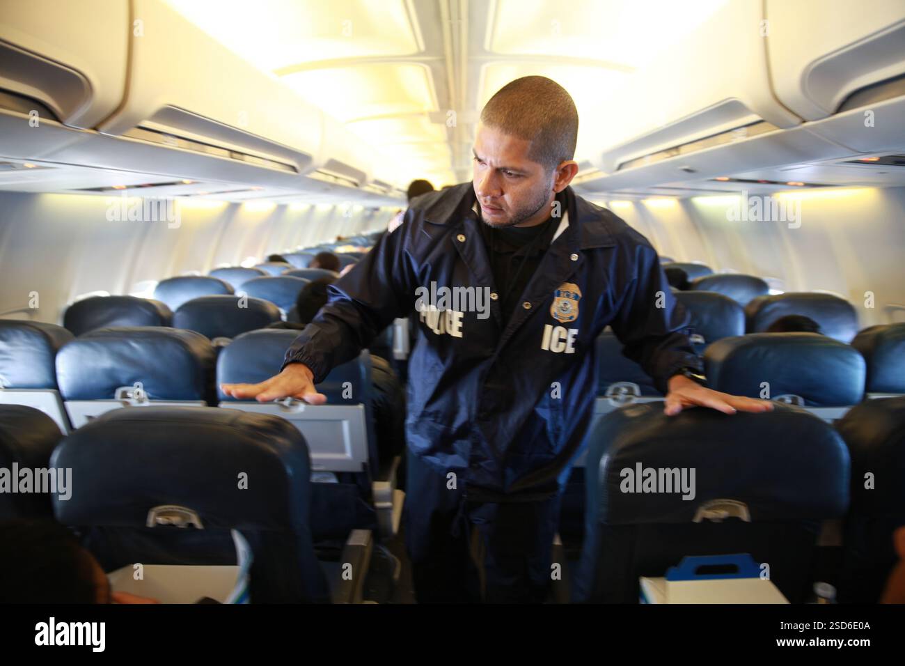 An ICE ERO officer patrols a removal flight Stock Photo - Alamy