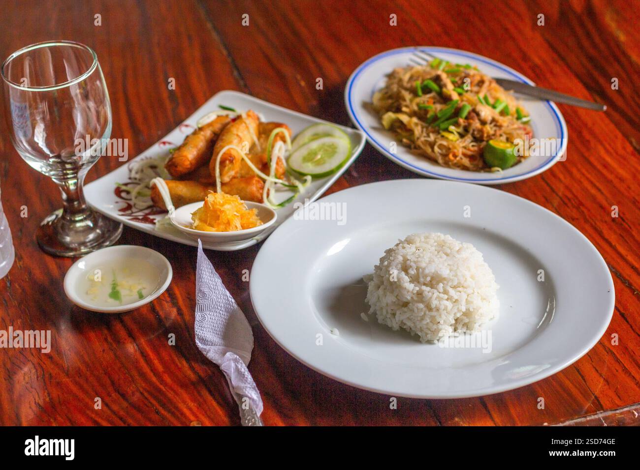 A traditional Filipino lunch spread of rice, lumpia, and pansit served ...