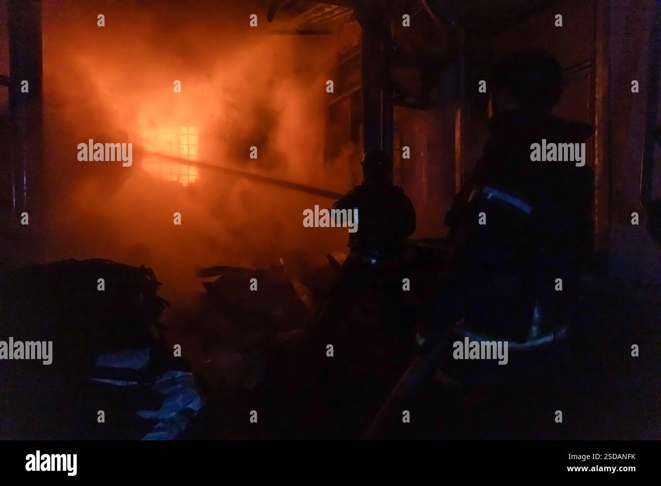 Firefighters work at a civil factory after the Russian attack in ...