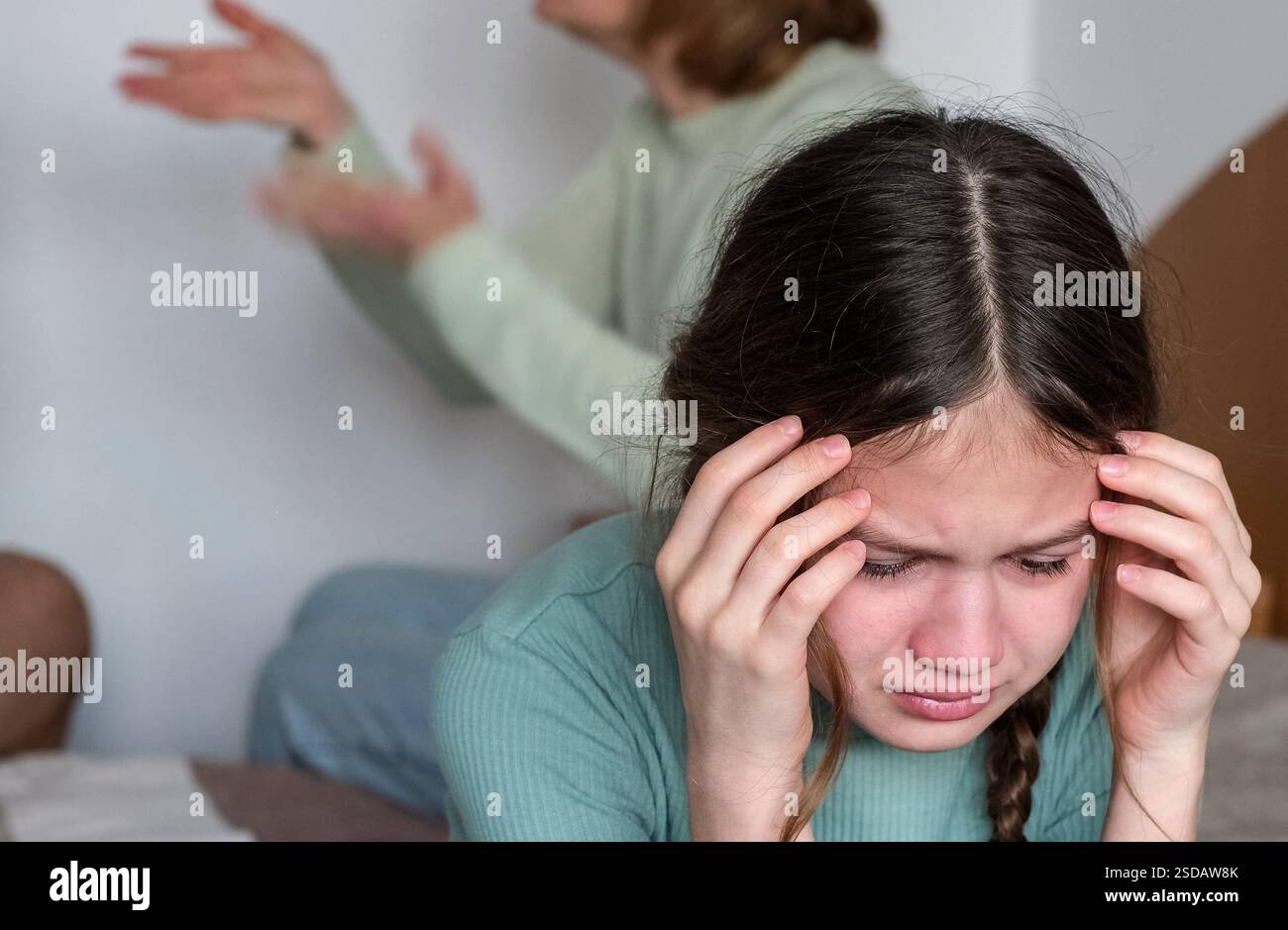 Little girl feeling upset while her parents are arguing on background ...