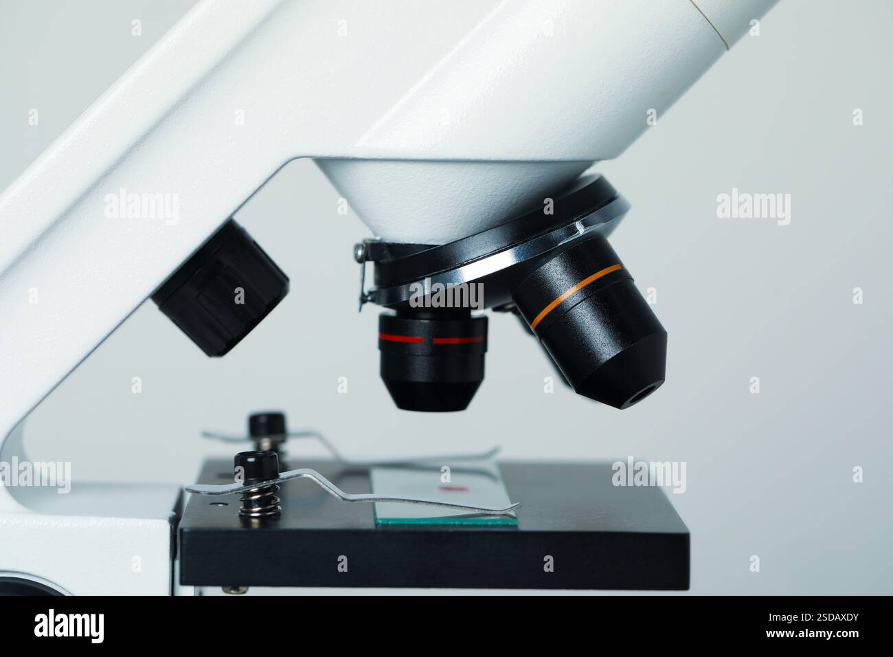 Science. Microscope with glass slide on light grey background, closeup ...