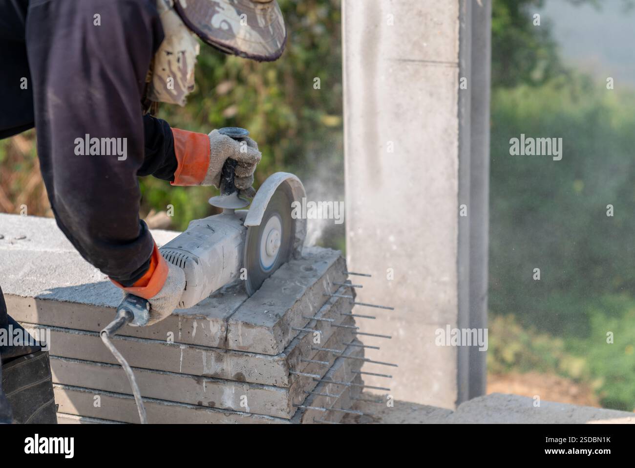 Building contractor using angle grinding to cut precast concrete slab ...