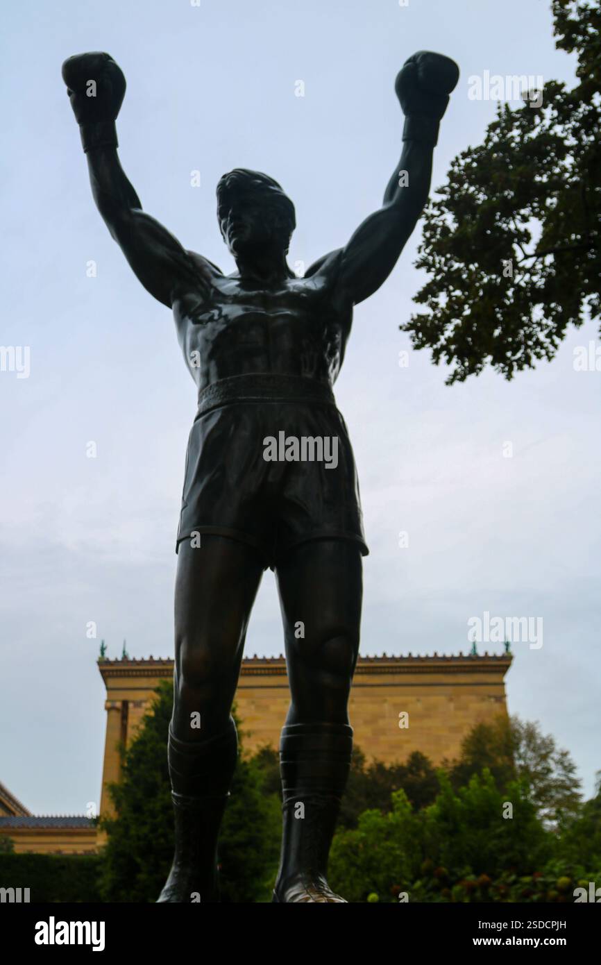Sculpture showcases a victorious boxer with raised fists in a park ...