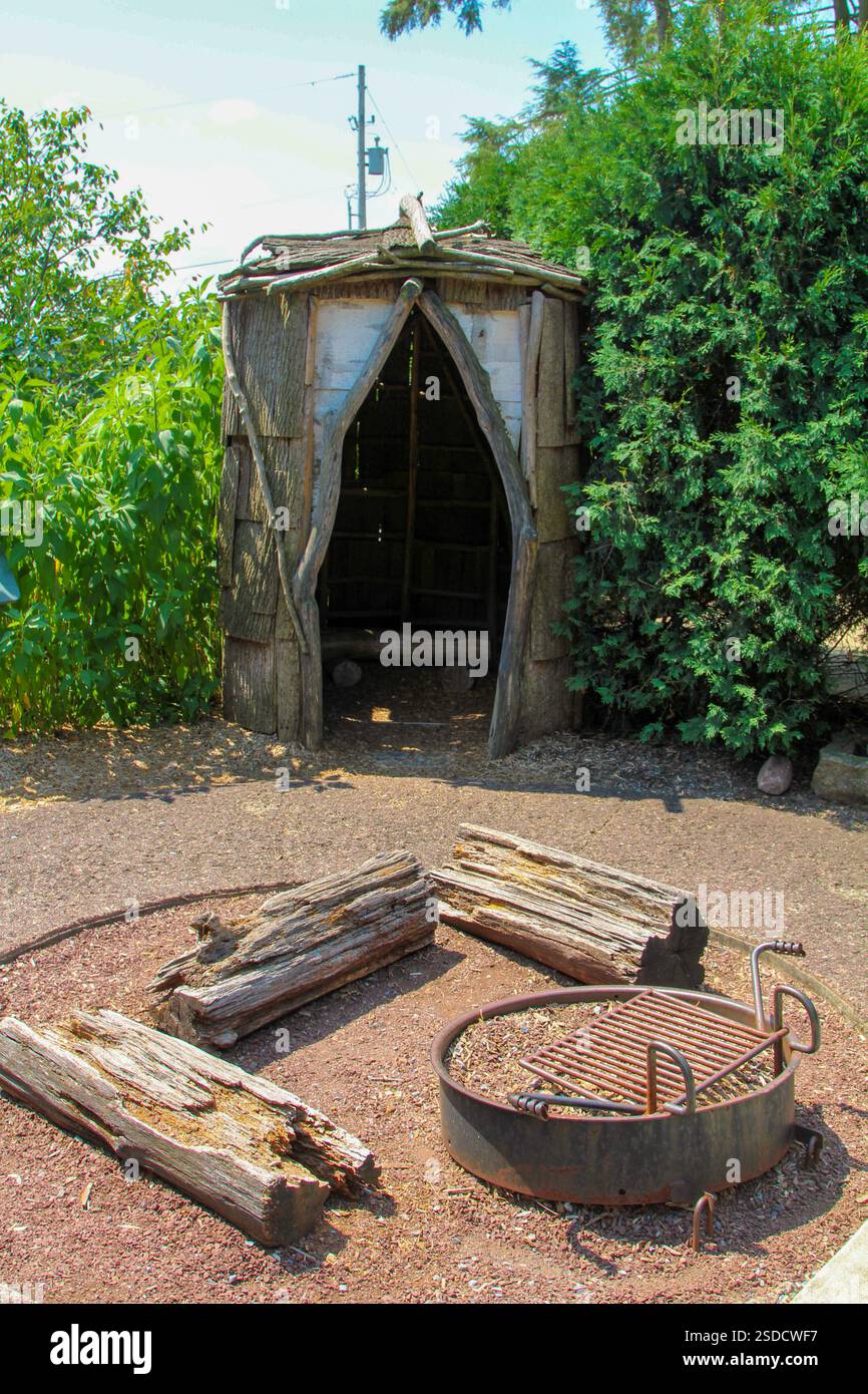 Rustic shelter surrounded by trees and a fire pit area Stock Photo - Alamy