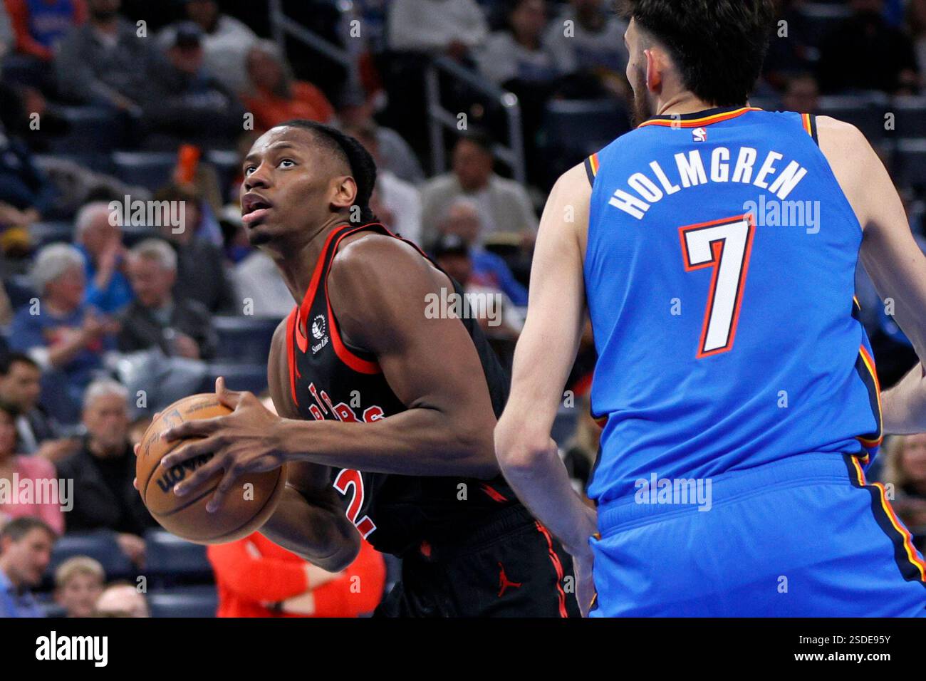 Toronto Raptors forward Jonathan Mogbo, left, goes to the basket next ...
