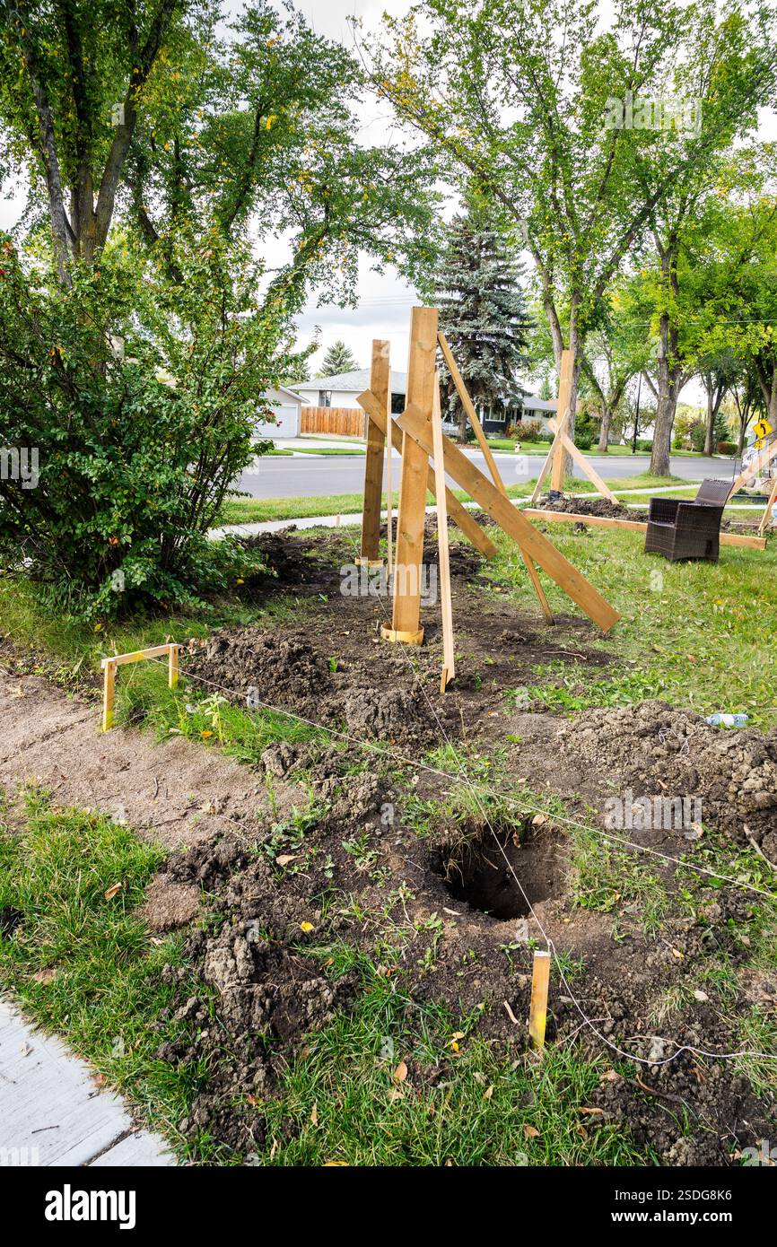 Building fence in progress - setting up poles in concrete base leveling ...