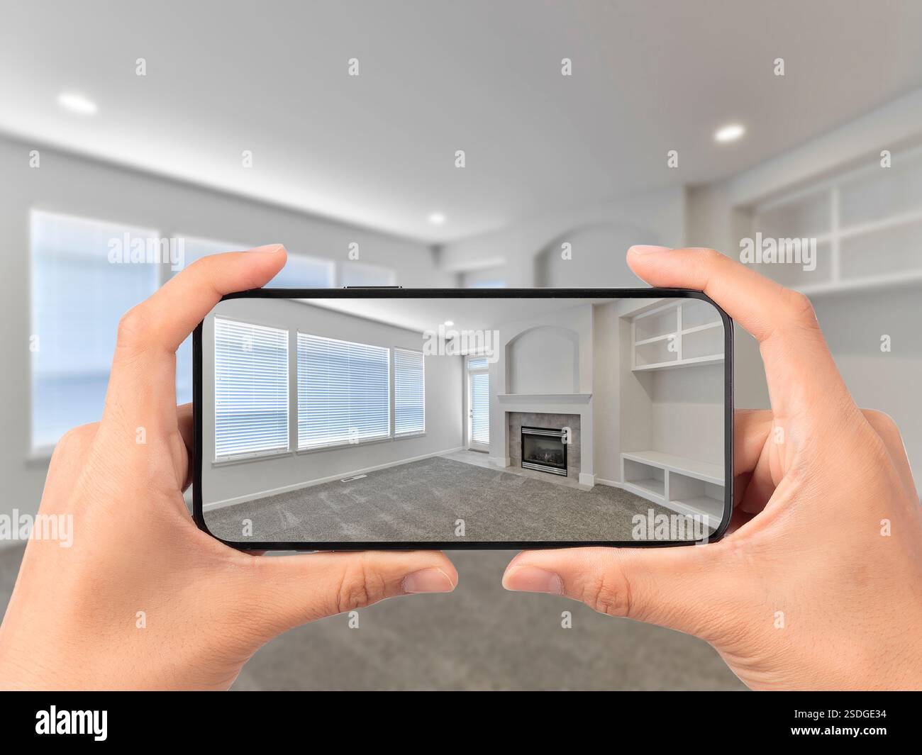 Cell phone taking a picture of an empty modern residential living room ...