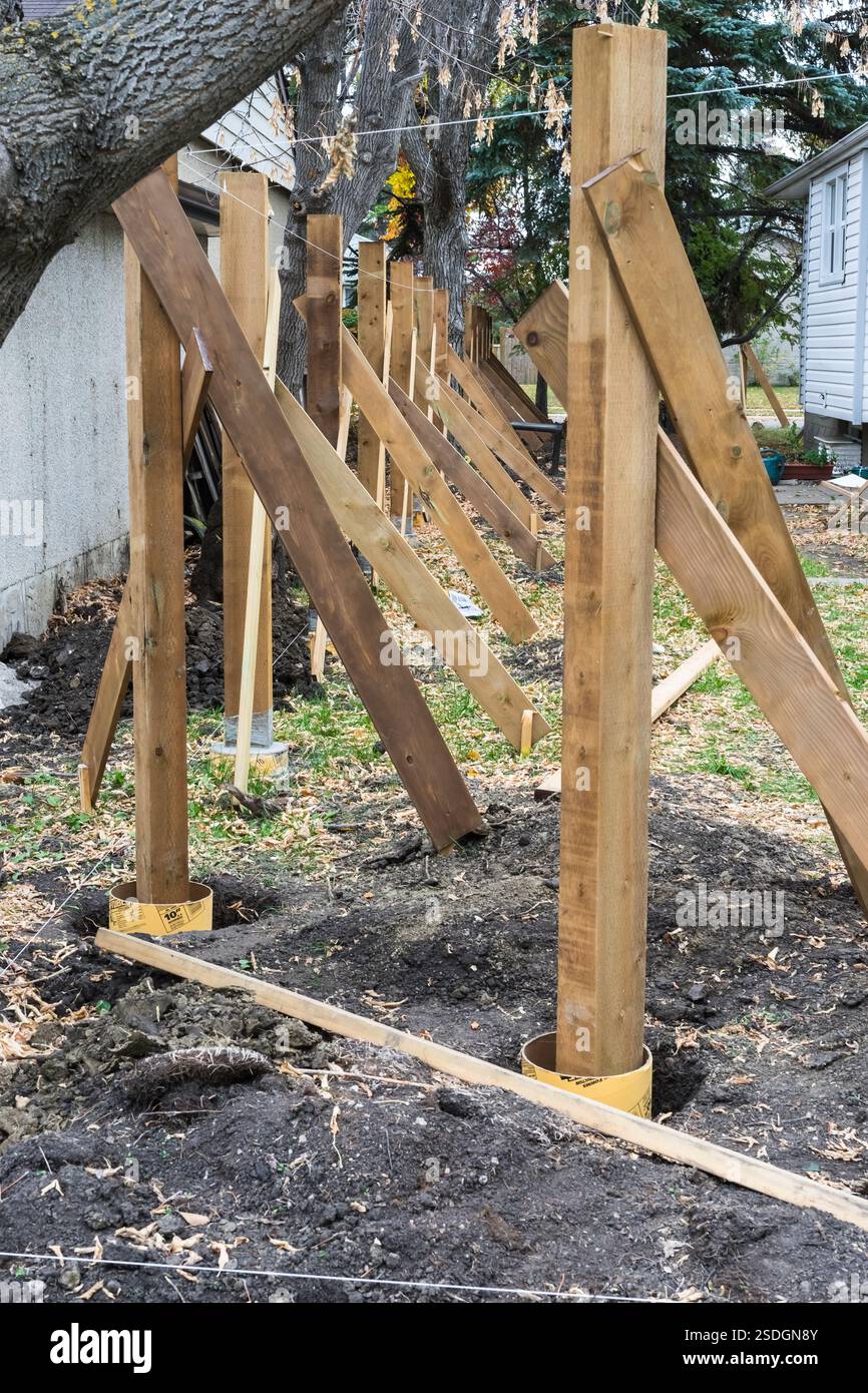 Row of wooden fence poles leveled vertically is ready for concrete ...