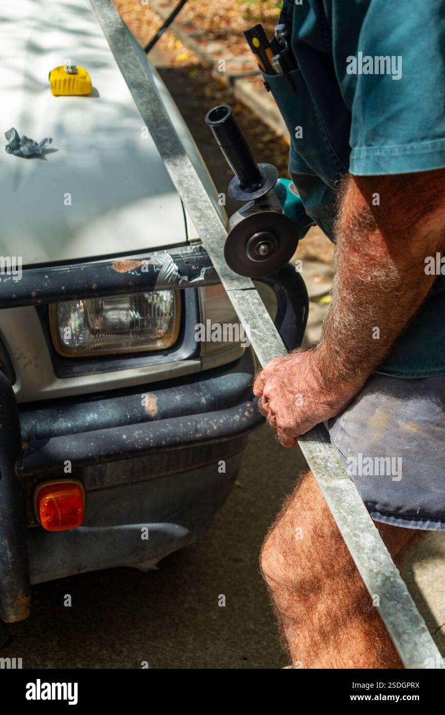 tradie cutting flat steel bar bull bar car across to his leg drill ...