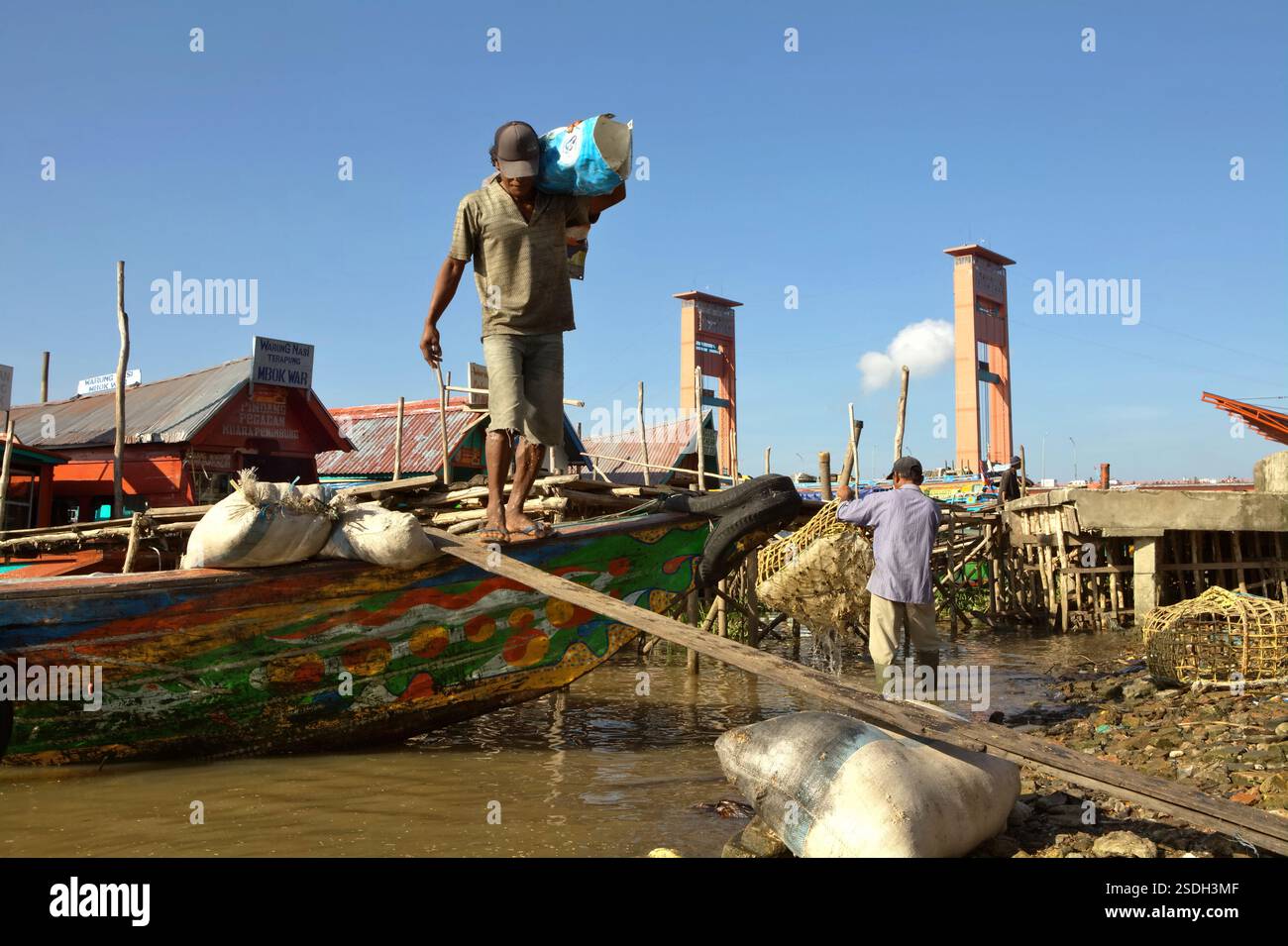 People's activities are photographed on Musi riverbank, in a background ...