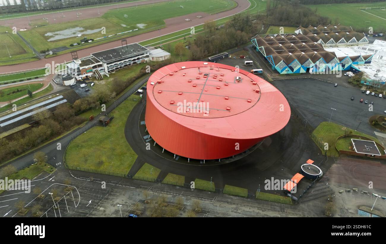Aerial view of a striking red circular building with a unique design ...