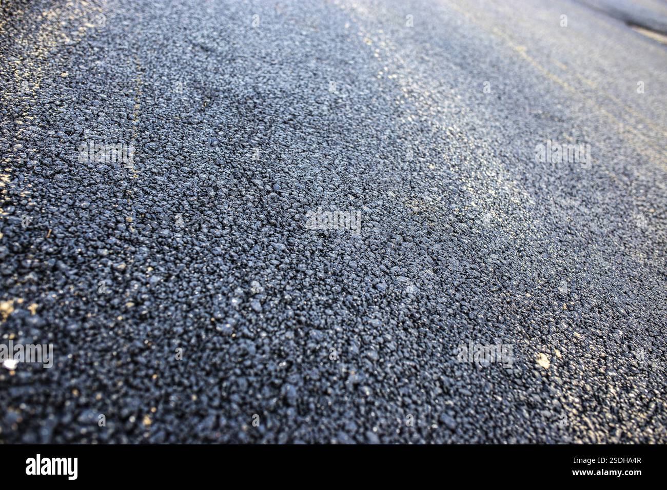 Granular texture of asphalt captured in close-up on a recently paved ...
