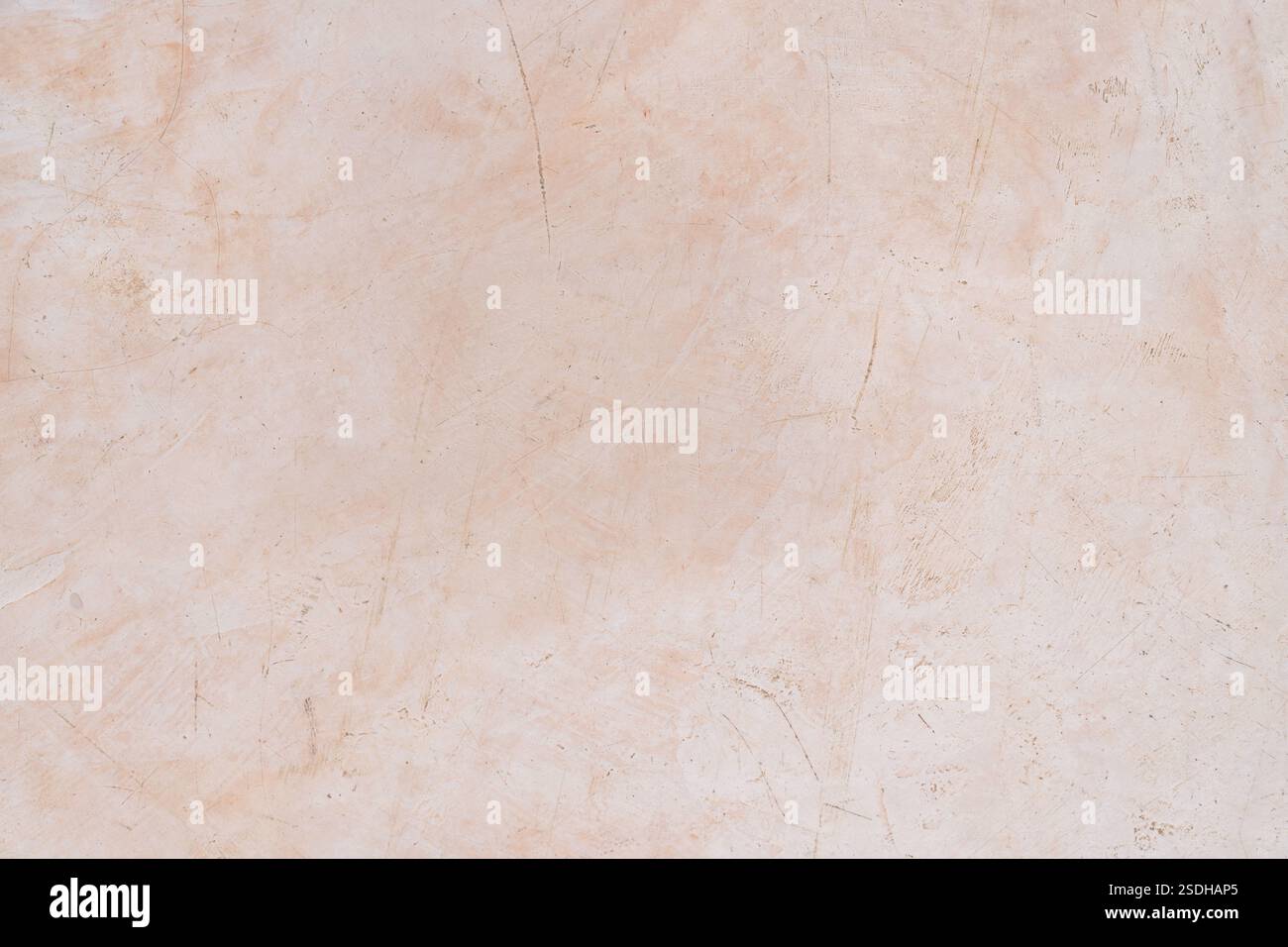 A textured beige plaster wall with subtle scratches and imperfections ...