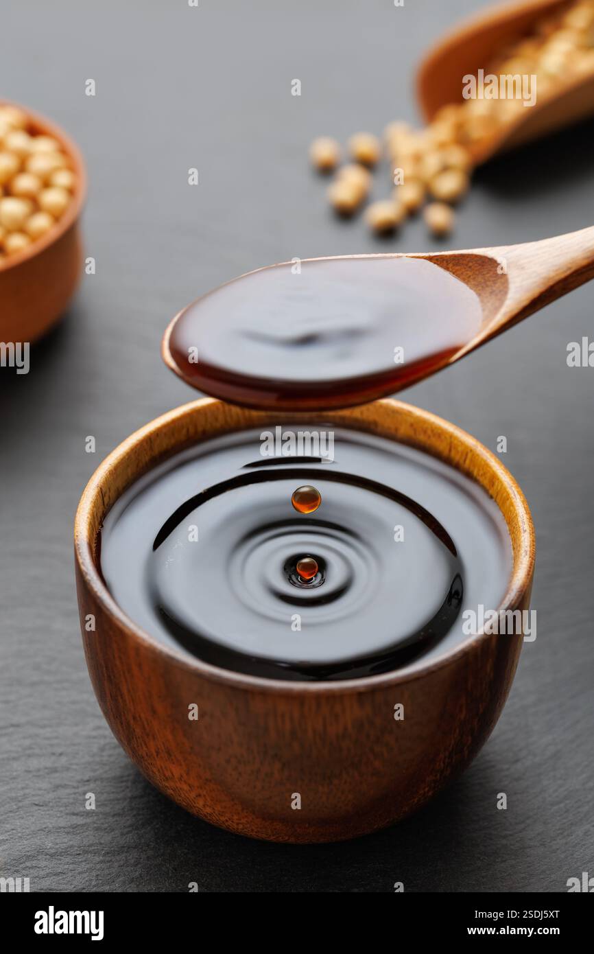 soy sauce pouring from spoon in bowl with splash and drop and dry ...