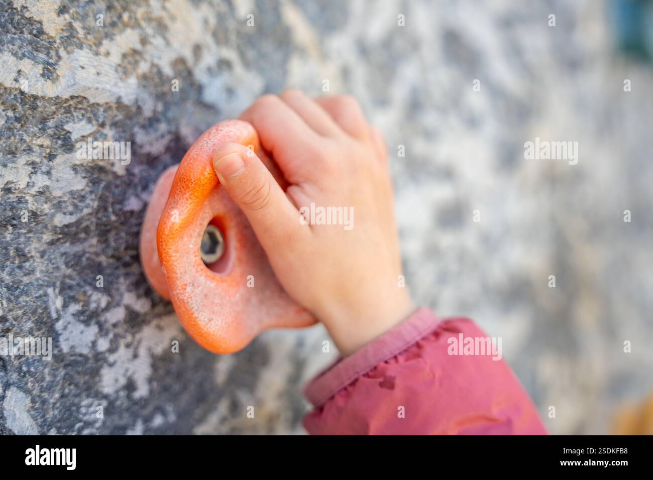 Close up view of hand of little girl climbing an artificial climbing ...