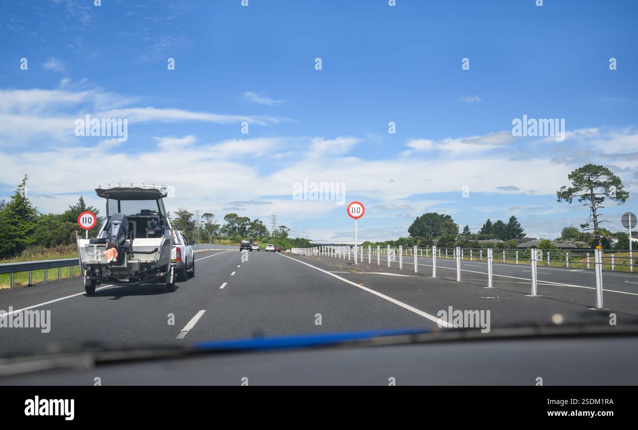 Car towing a boat on Waikato Expressway. 110 kmh road speed signs by ...