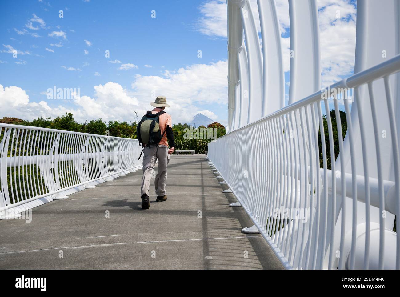 Man walking on the Te Rewa Rewa Bridge. Mt Taranaki in the distance ...