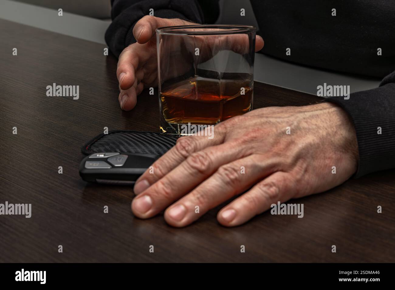 Drunk man lying on the table with a glass of alcohol, car keys on the ...
