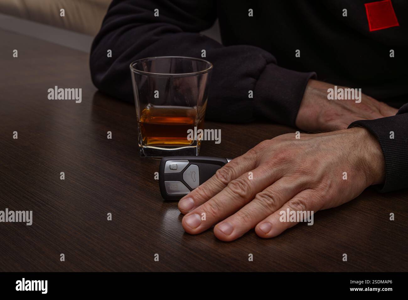 Drunk man lying on the table with a glass of alcohol, car keys on the ...