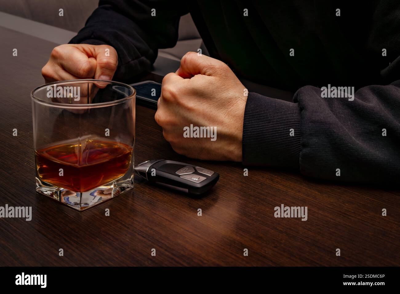 Drunk man lying on the table with a glass of alcohol, car keys on the ...