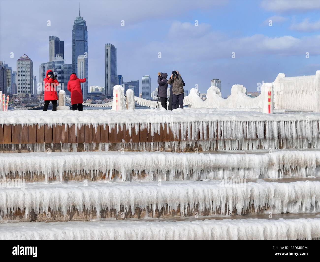 Tourists view the sea ice at the seaside in Yantai, East China's ...