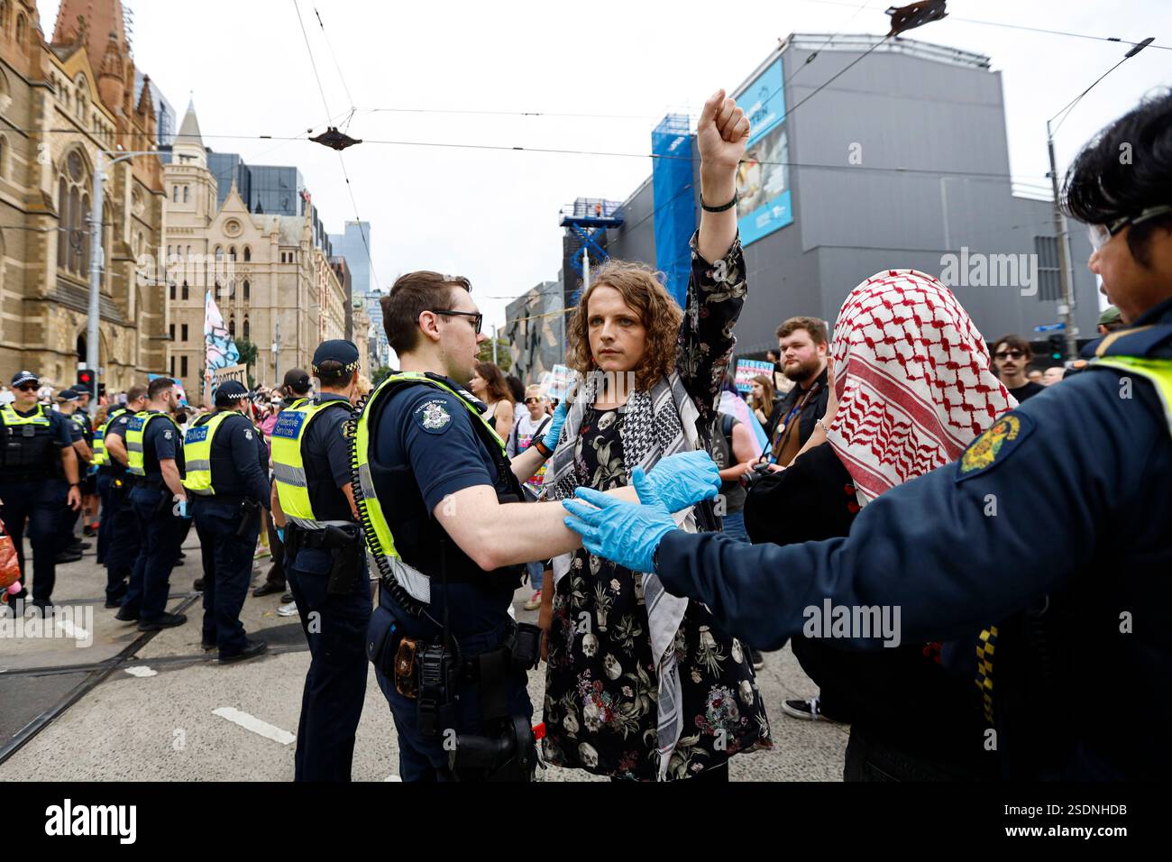 A protester raises a fist as police block the rally near Flinders ...