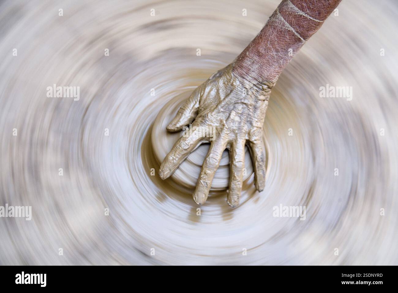 Pottery, artist muddy hands making clay pot giving shape on spinning ...