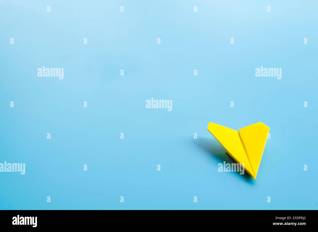 Low view of origami yellow paper airplane with customizable space for ...