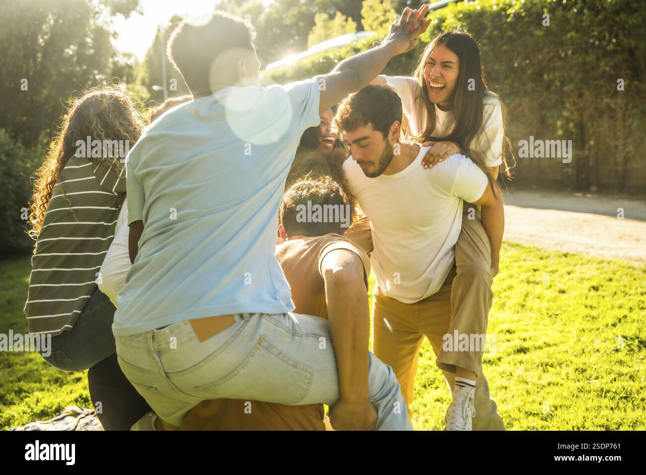 Multi-ethnic young happy friends playing games piggybacking enjoying a ...